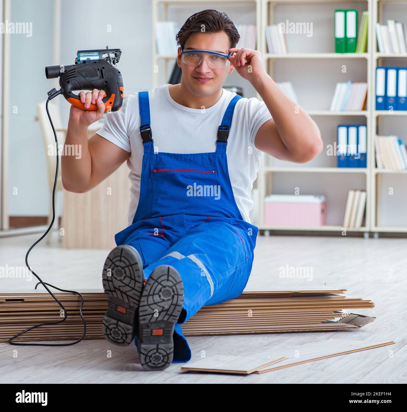 The young worker working on floor laminate tiles Stock Photo - Alamy