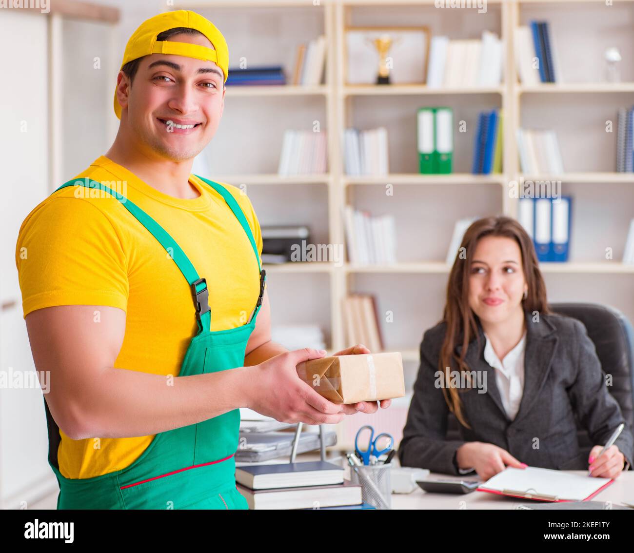 The postman delivering parcel to the office Stock Photo - Alamy