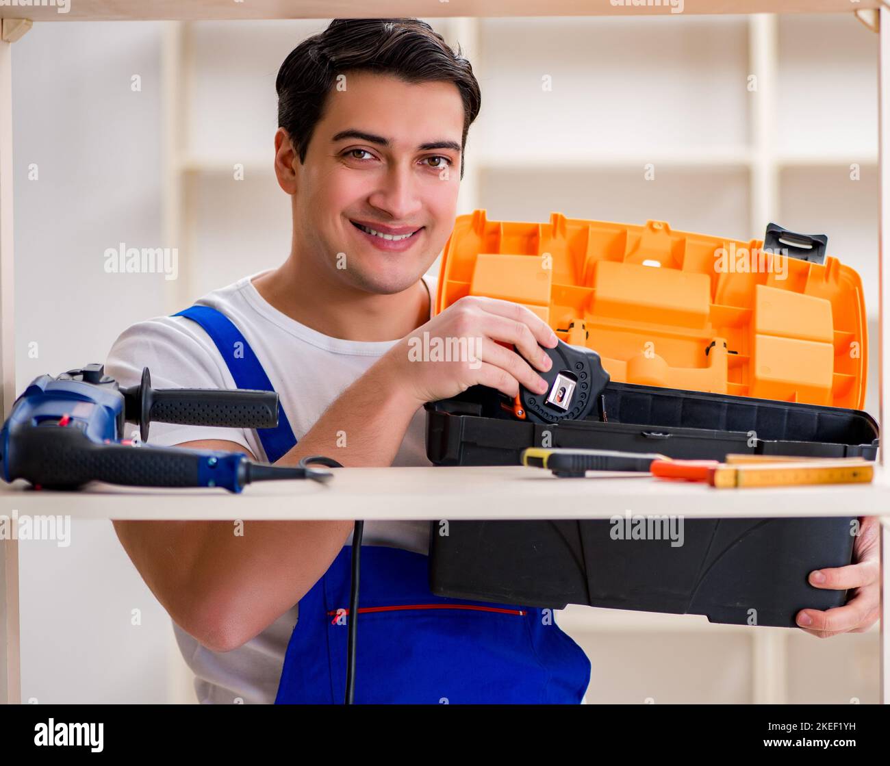 The worker man repairing assembling bookshelf Stock Photo - Alamy