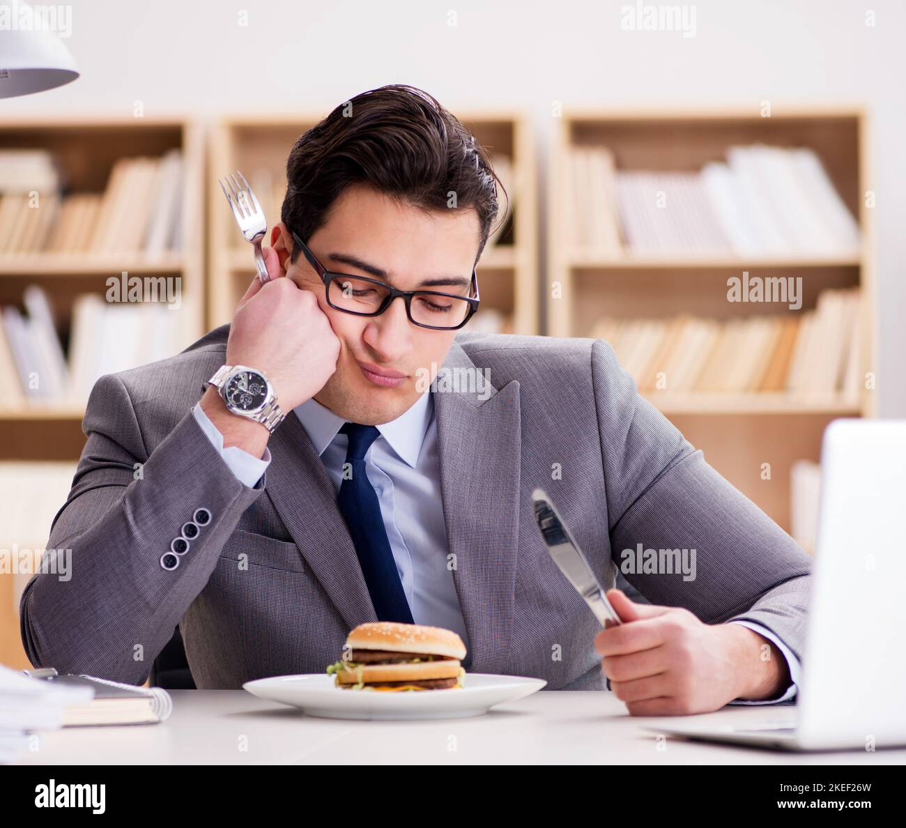 The hungry funny businessman eating junk food sandwich Stock Photo - Alamy