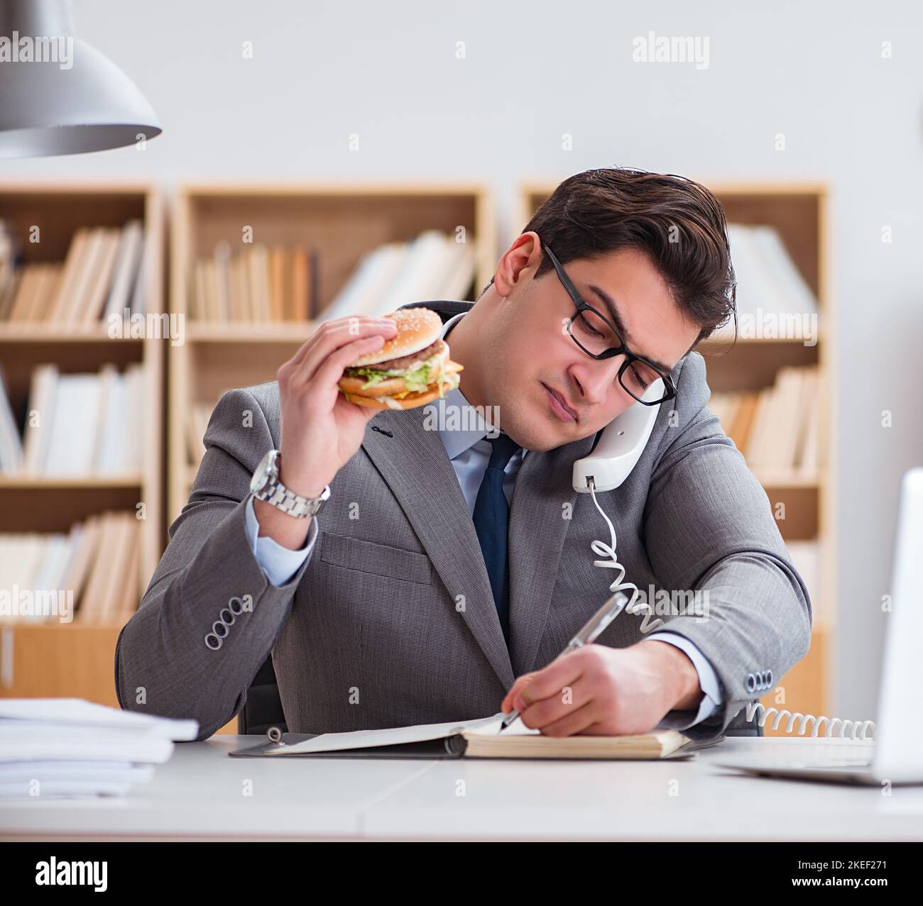 The hungry funny businessman eating junk food sandwich Stock Photo - Alamy