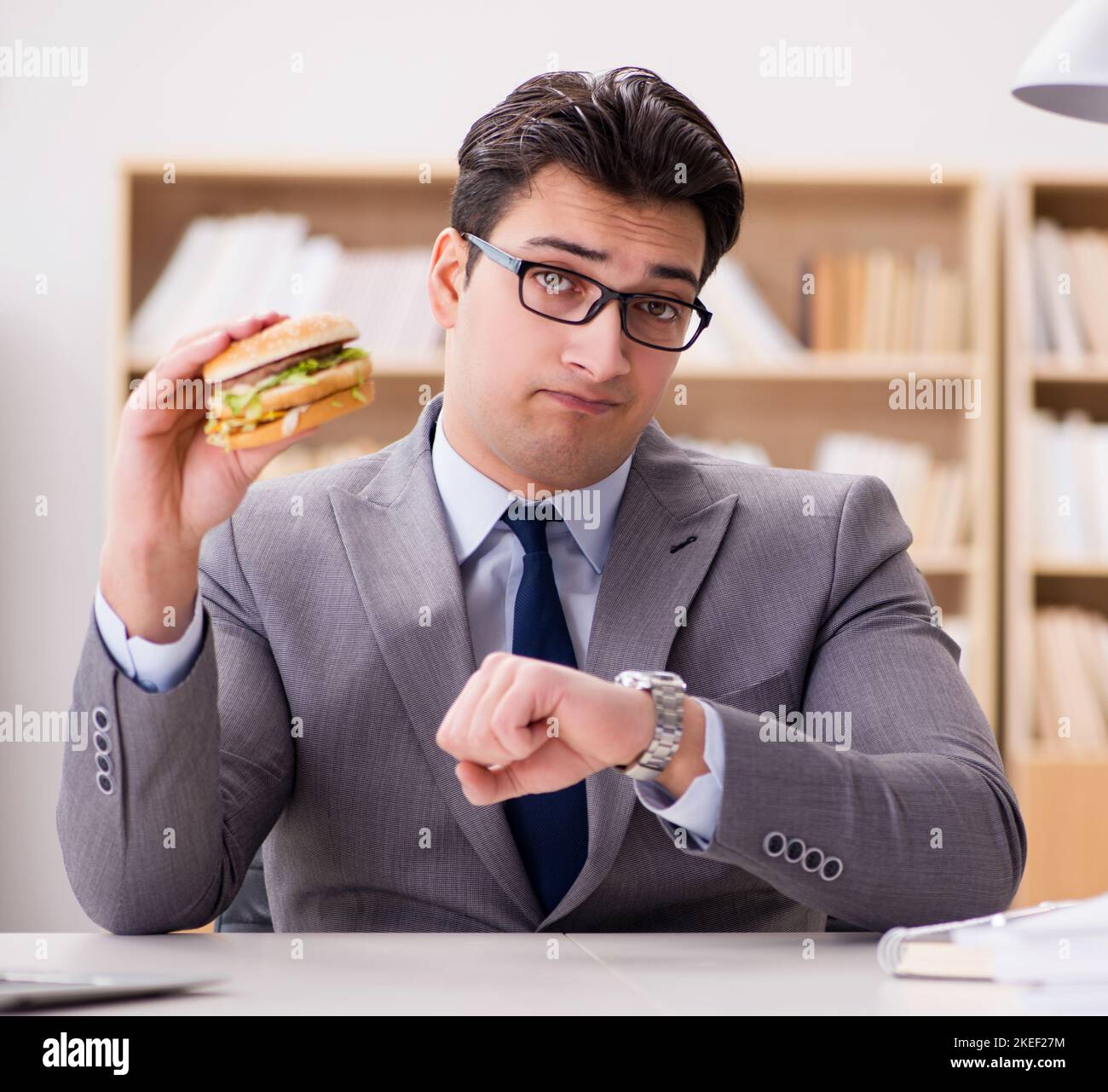 The hungry funny businessman eating junk food sandwich Stock Photo - Alamy