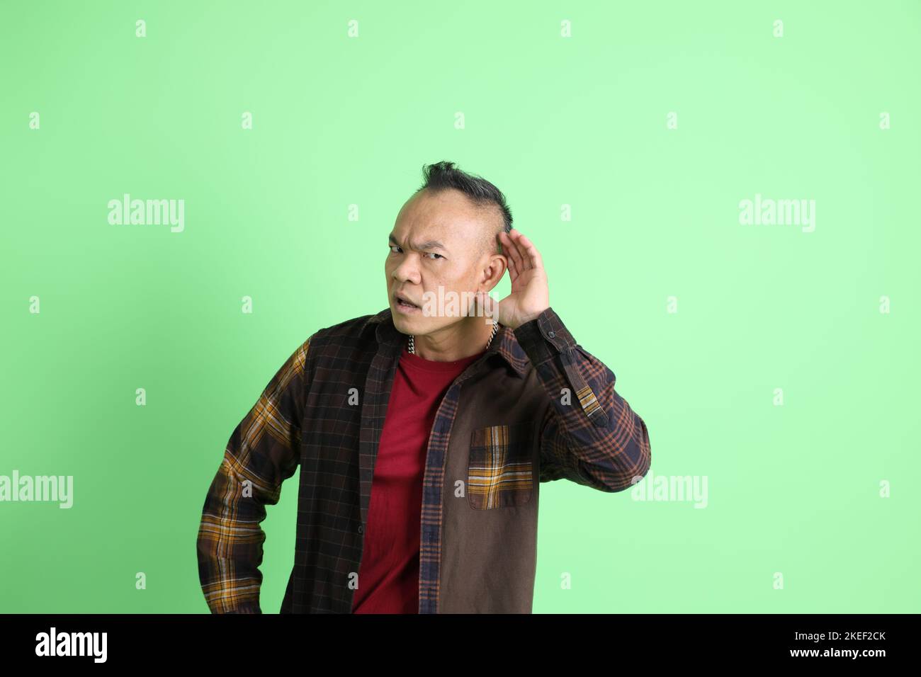 The 40s adult Asian man with plaid shirt standing on the green ...