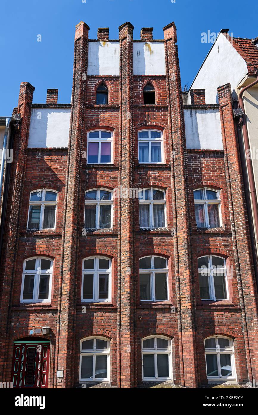 A facade with windows of a historic, gothic tenement house in the city ...