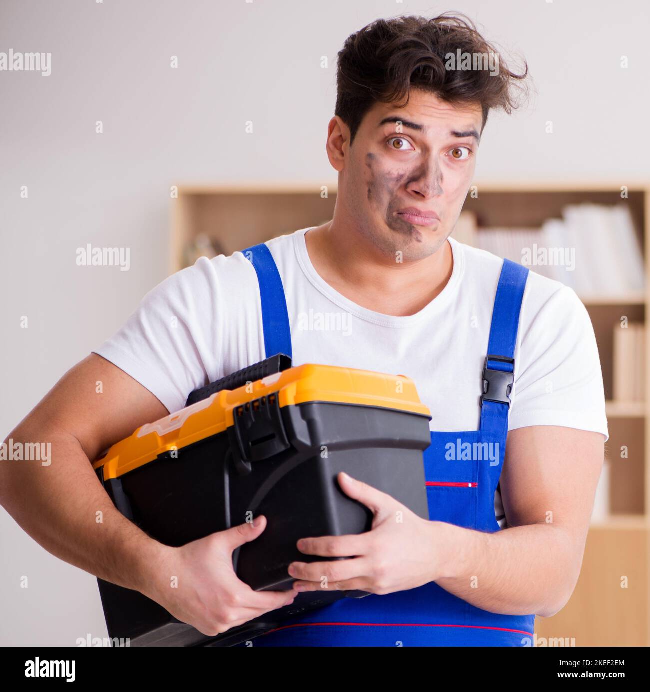 The funny worker with dirty face and toolkit Stock Photo - Alamy