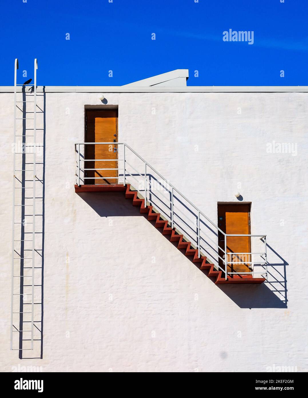 A closeup of a grey metal stairs on the side of a minimalistic building ...