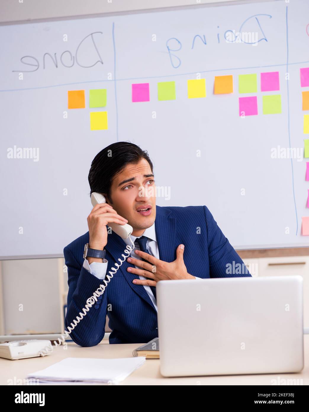 The young handsome employee in front of whiteboard with to-do list ...