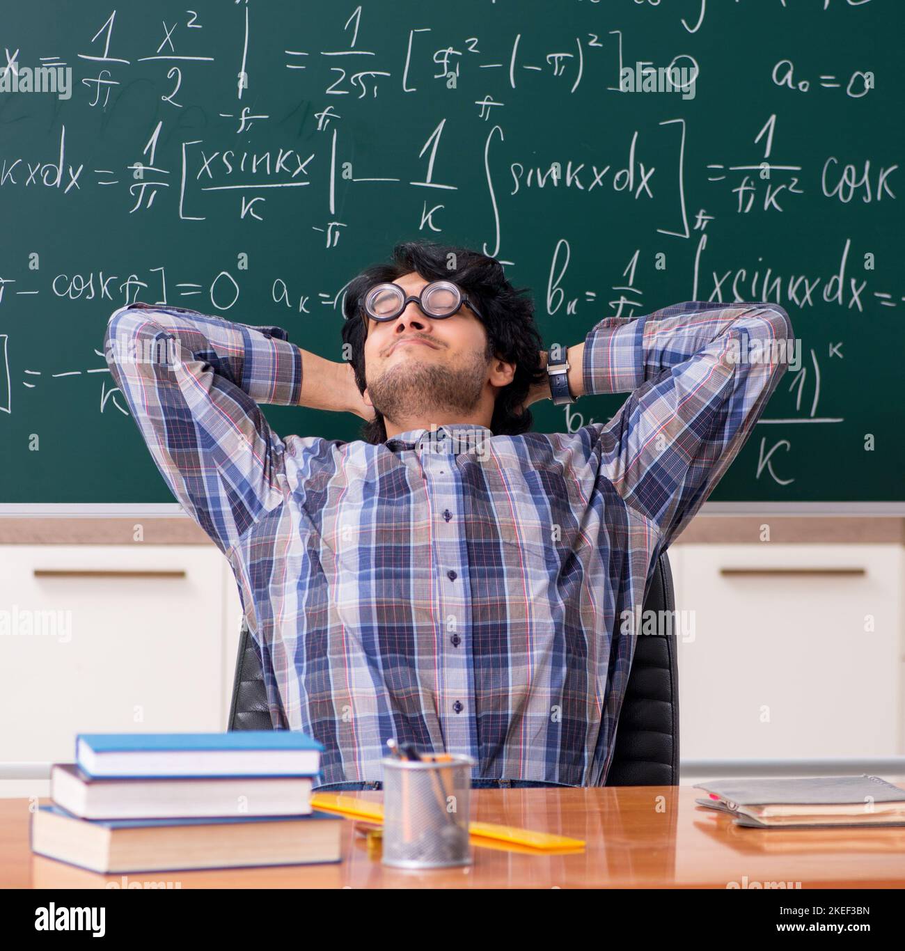 The funny male math teacher in the classroom Stock Photo - Alamy