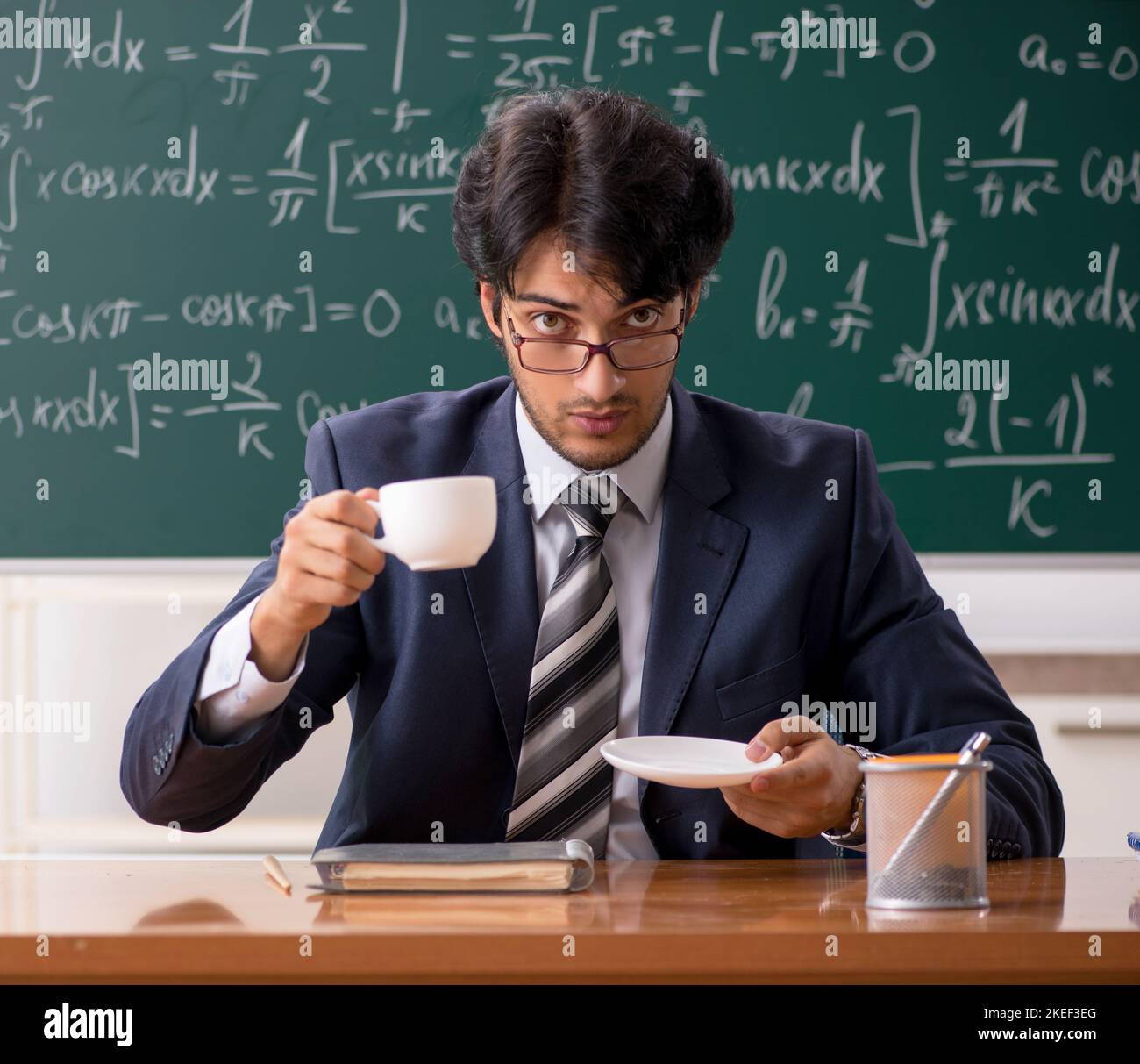 The young male math teacher in classroom Stock Photo - Alamy