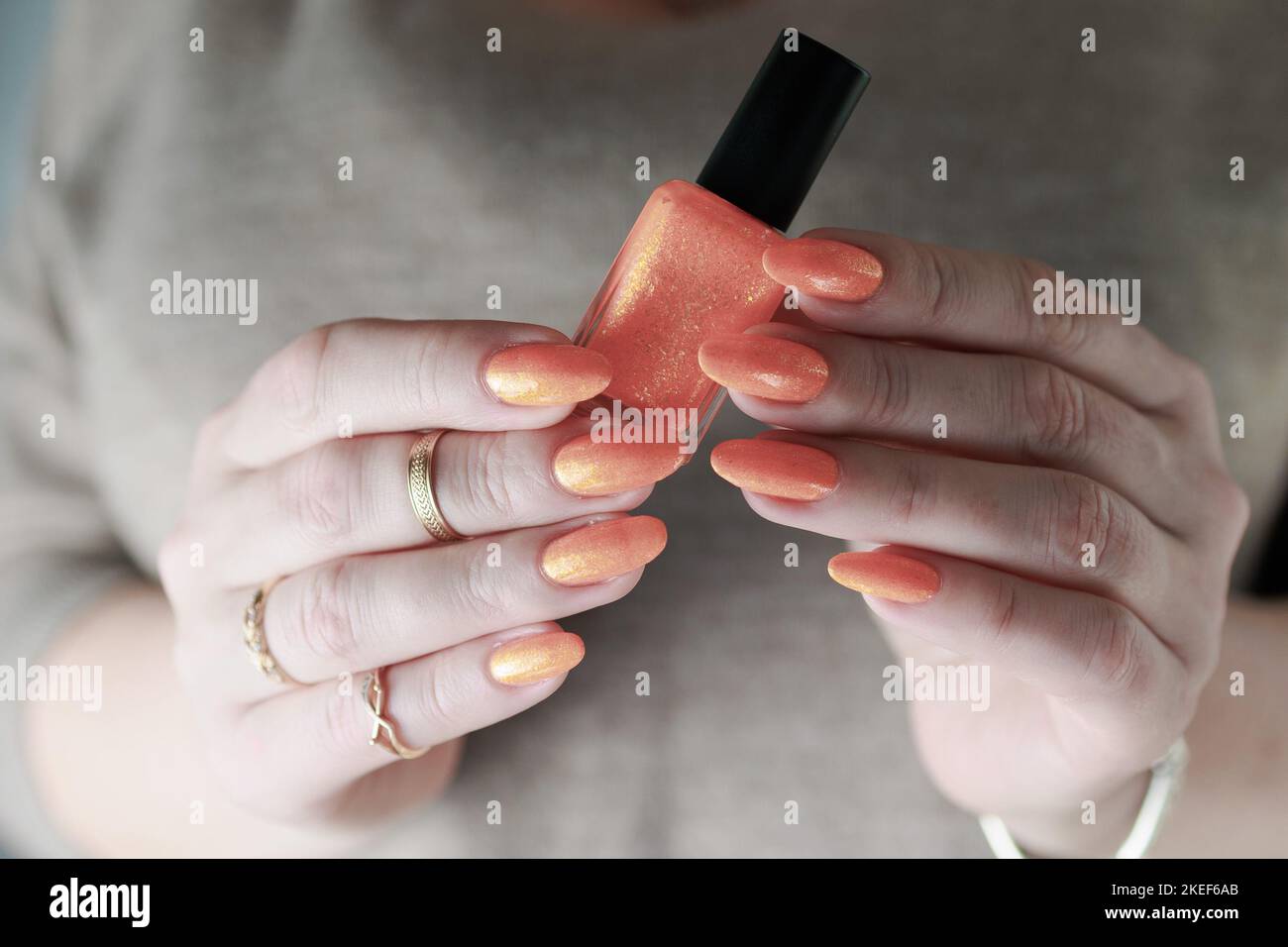 Female hand with long nails and a yellow orange nail polish Stock Photo ...