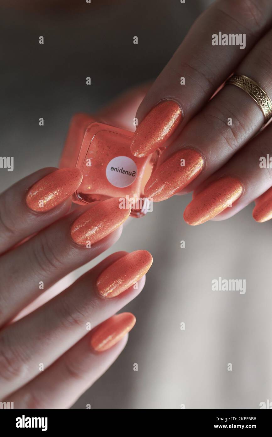 Female hand with long nails and a yellow orange nail polish Stock Photo ...