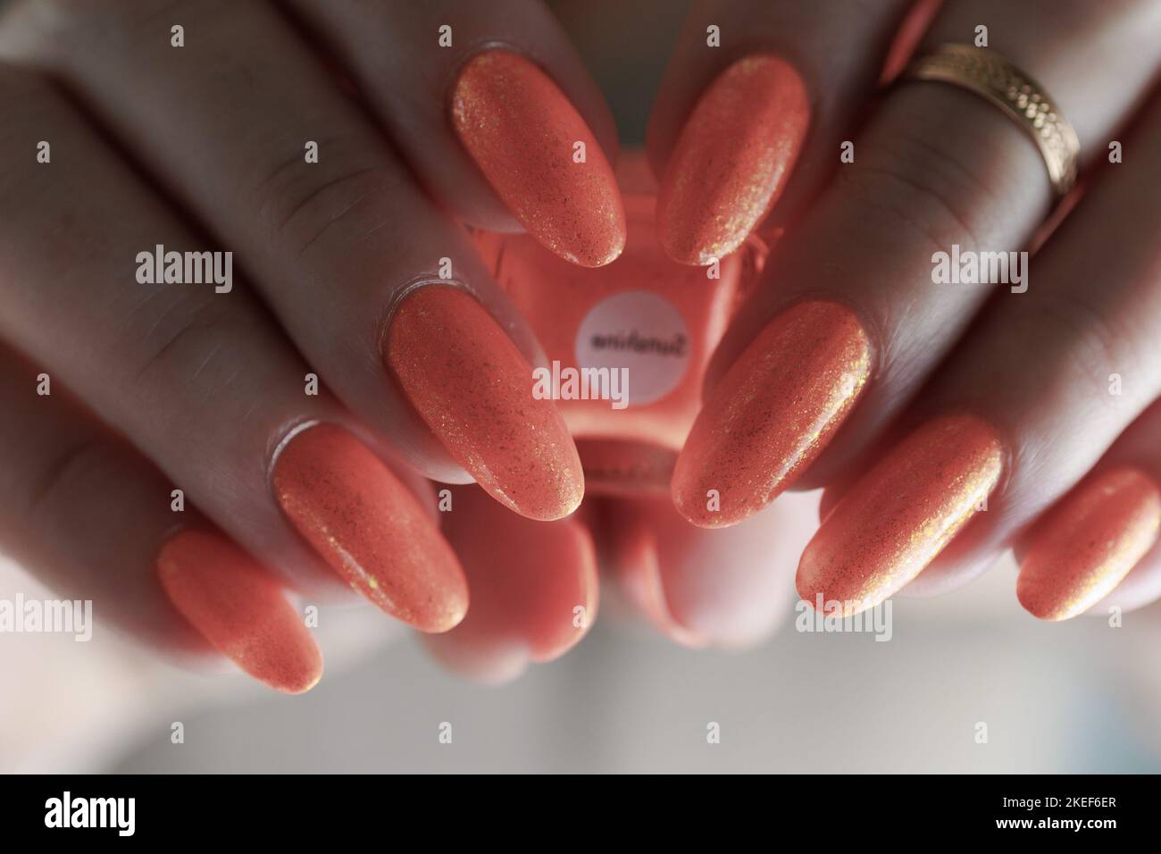 Female hand with long nails and a yellow orange nail polish Stock Photo ...