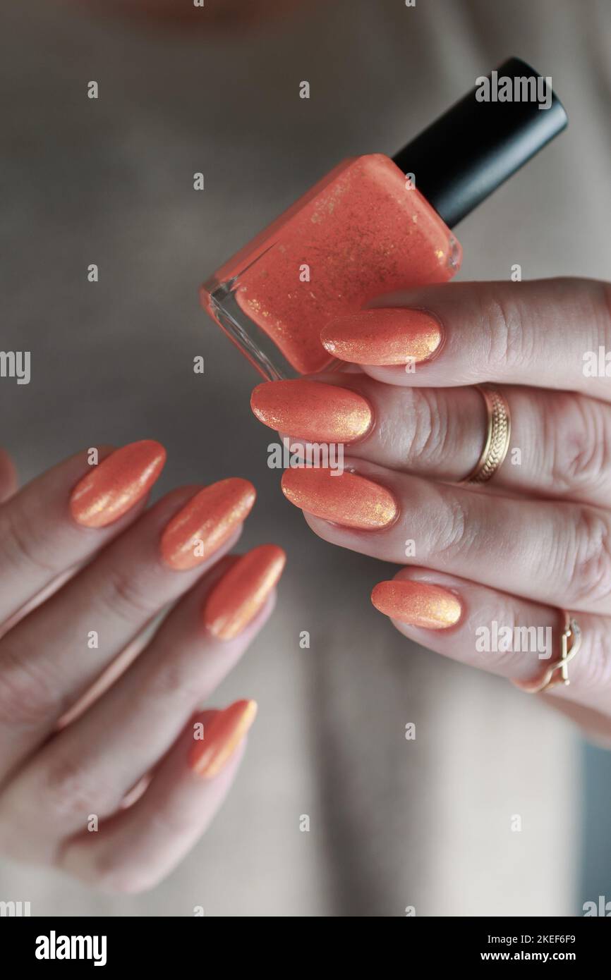 Female hand with long nails and a yellow orange nail polish Stock Photo ...