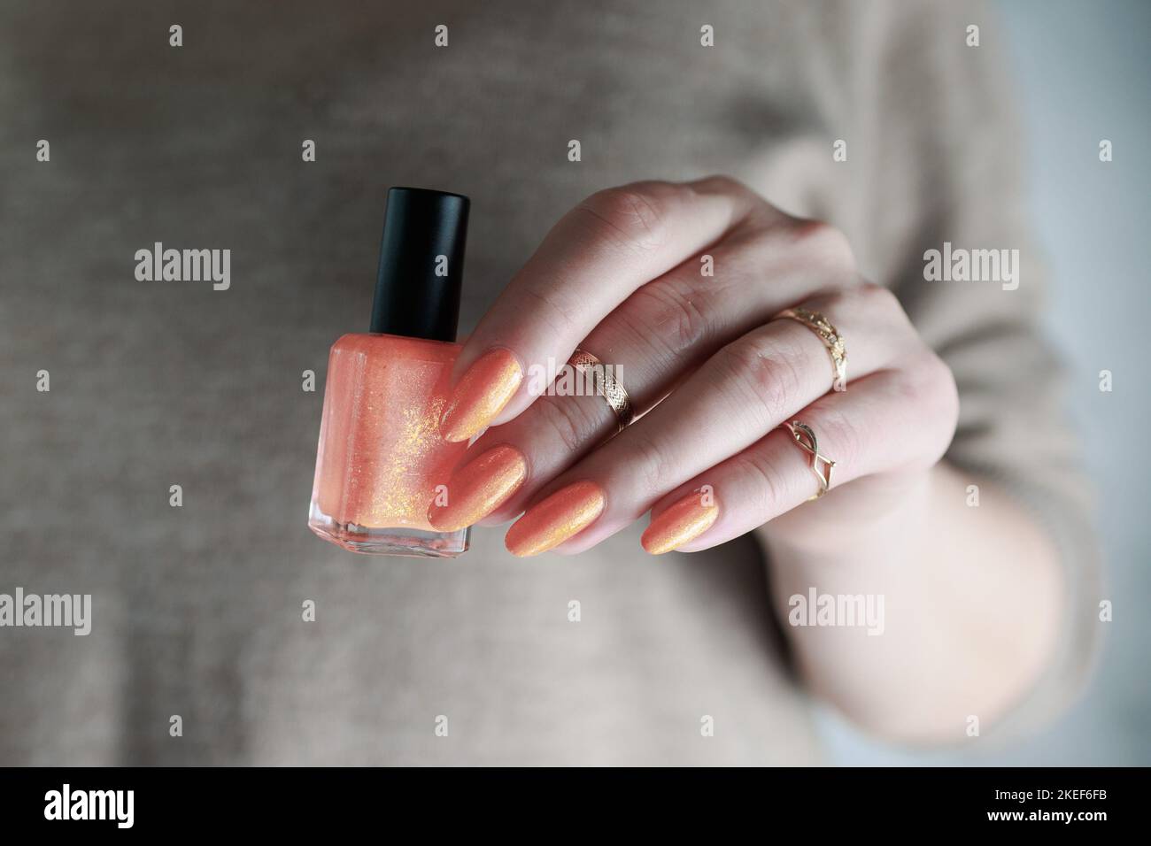 Female hand with long nails and a yellow orange nail polish Stock Photo ...