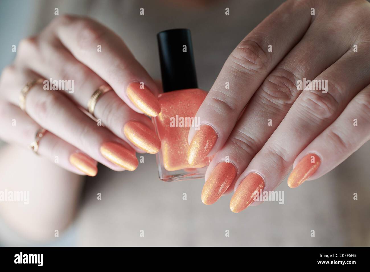 Female hand with long nails and a yellow orange nail polish Stock Photo ...