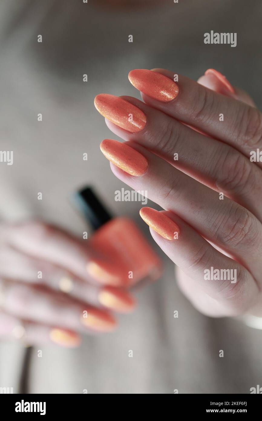 Female hand with long nails and a yellow orange nail polish Stock Photo ...