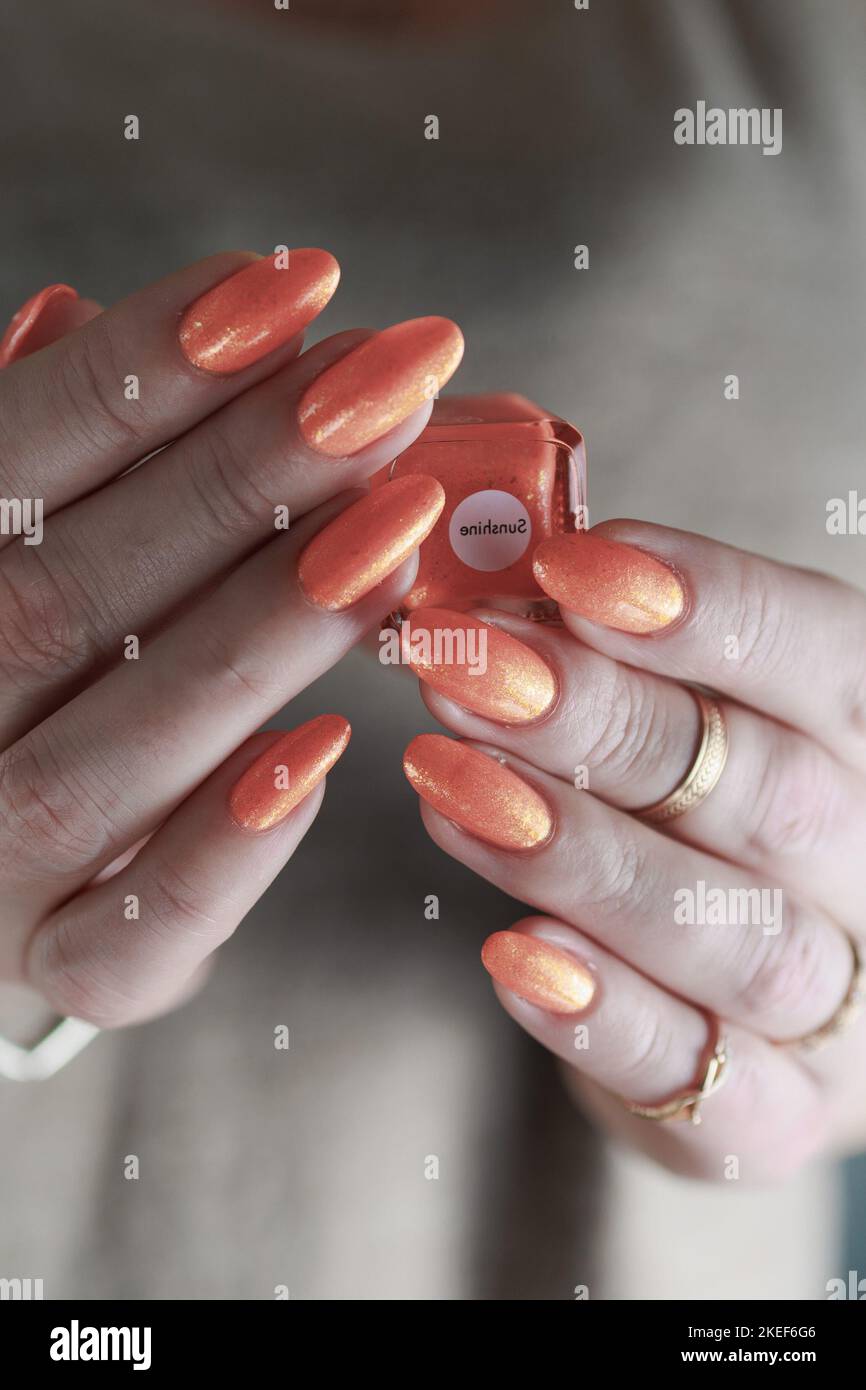 Female hand with long nails and a yellow orange nail polish Stock Photo ...