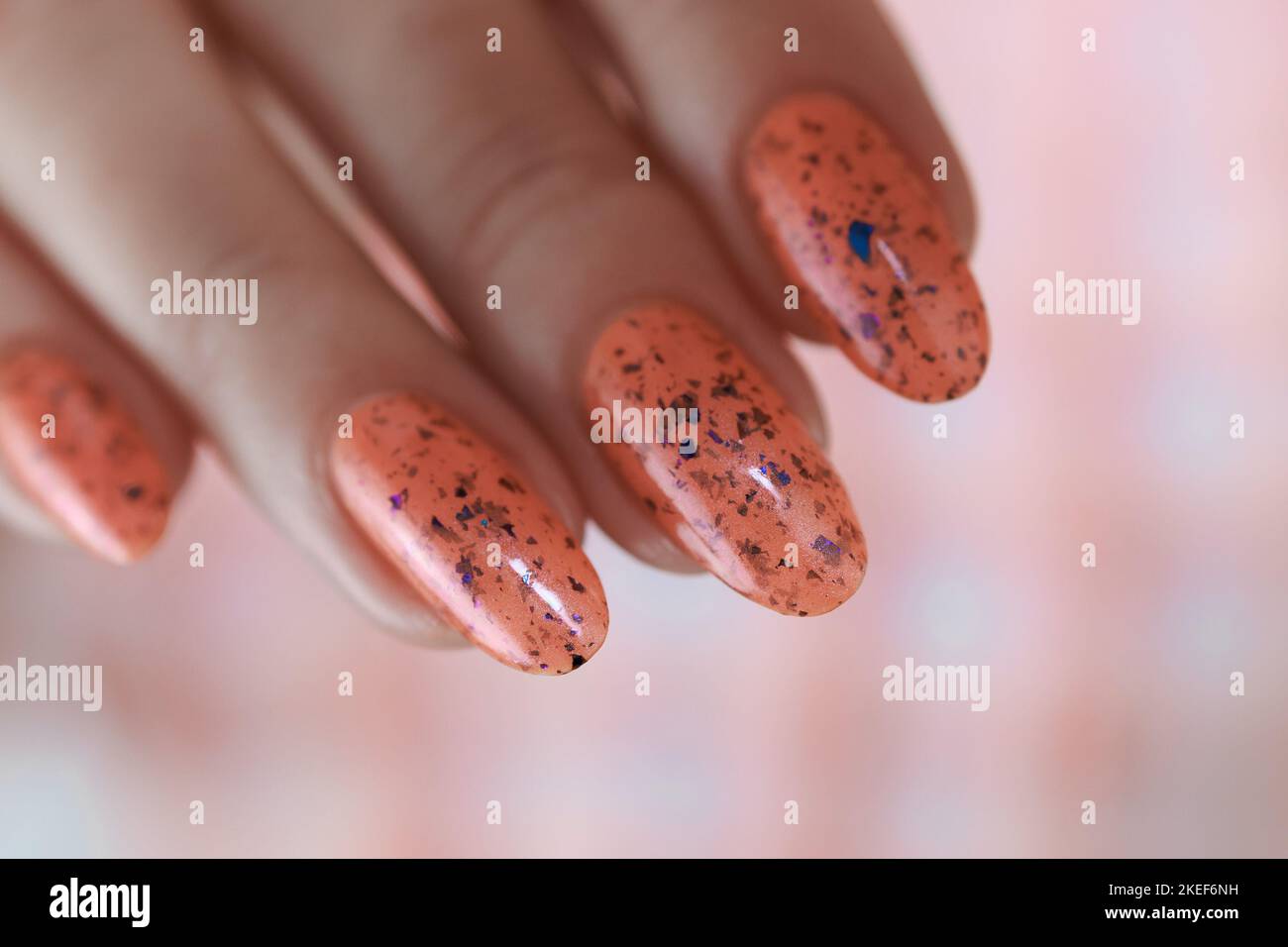Woman's hands with long nails and a bottle of orange nail polish Stock ...