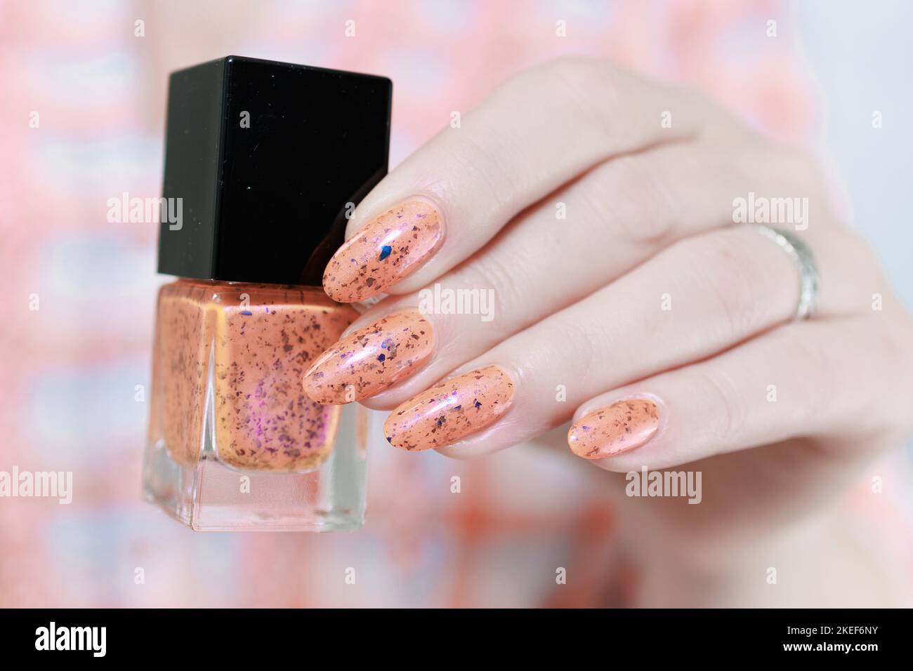 Woman's hands with long nails and a bottle of orange nail polish Stock ...