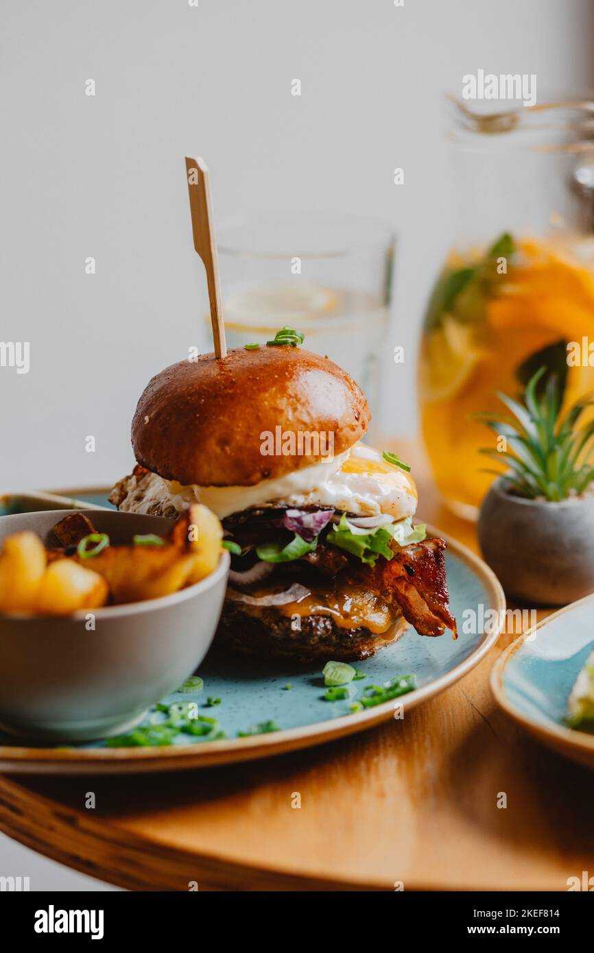 A vertical closeup shot of a gourmet juicy burger on a restaurant table ...