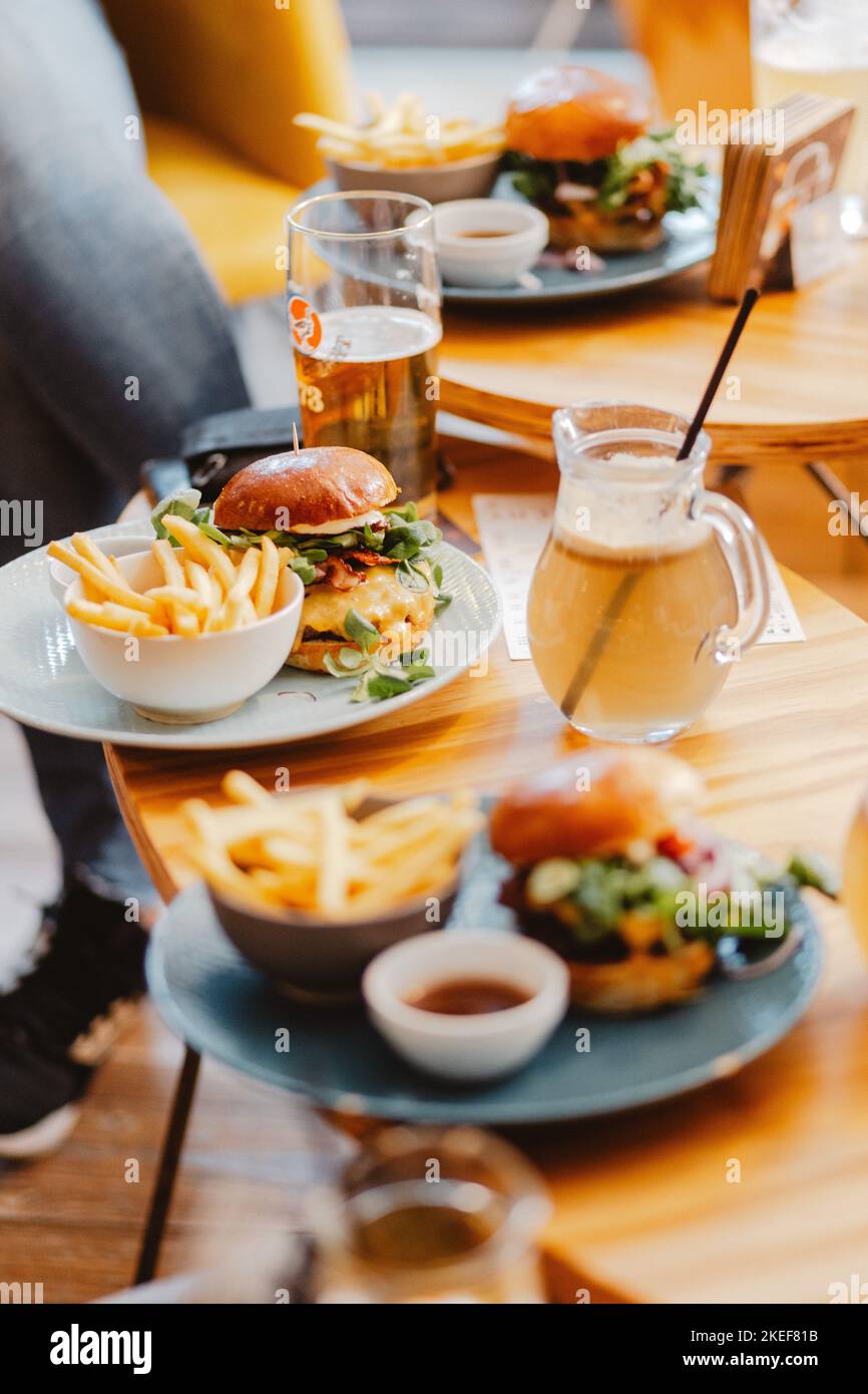 A vertical shot of a gourmet fast food restaurant table with burgers ...