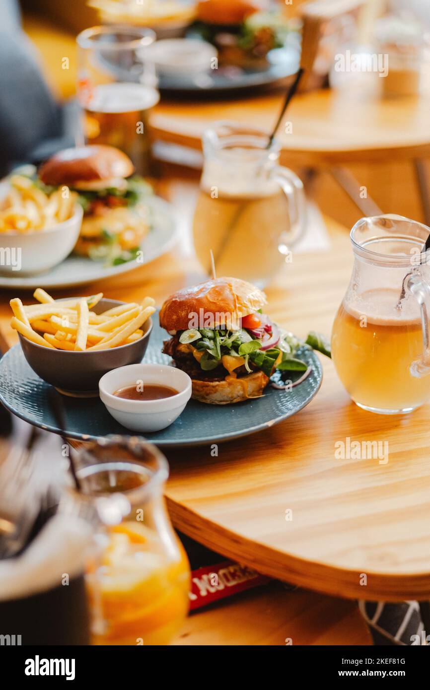 A vertical shot of a gourmet fast food restaurant table with burgers ...