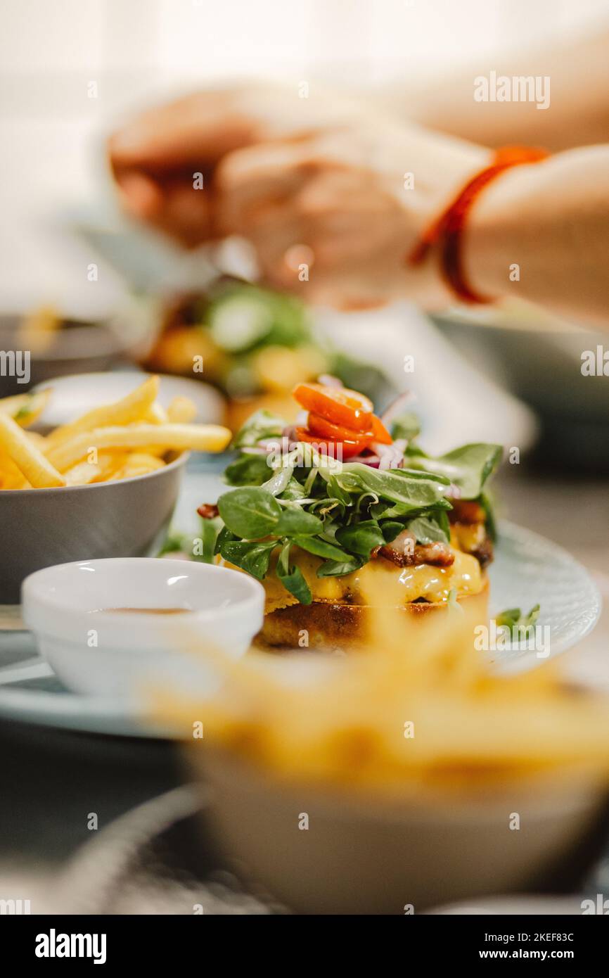 A vertical closeup shot of a gourmet burger being prepared at a ...