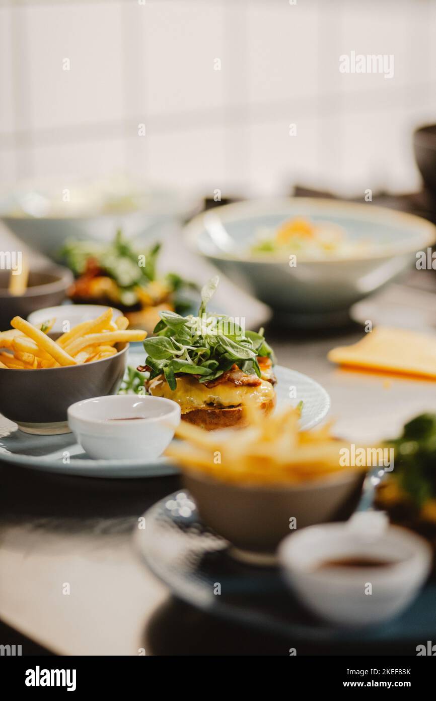 A vertical closeup shot of a gourmet burger being prepared at a ...
