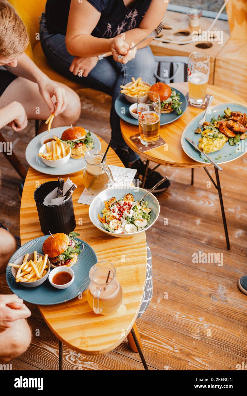 A vertical shot of a gourmet fast food restaurant table with burgers ...