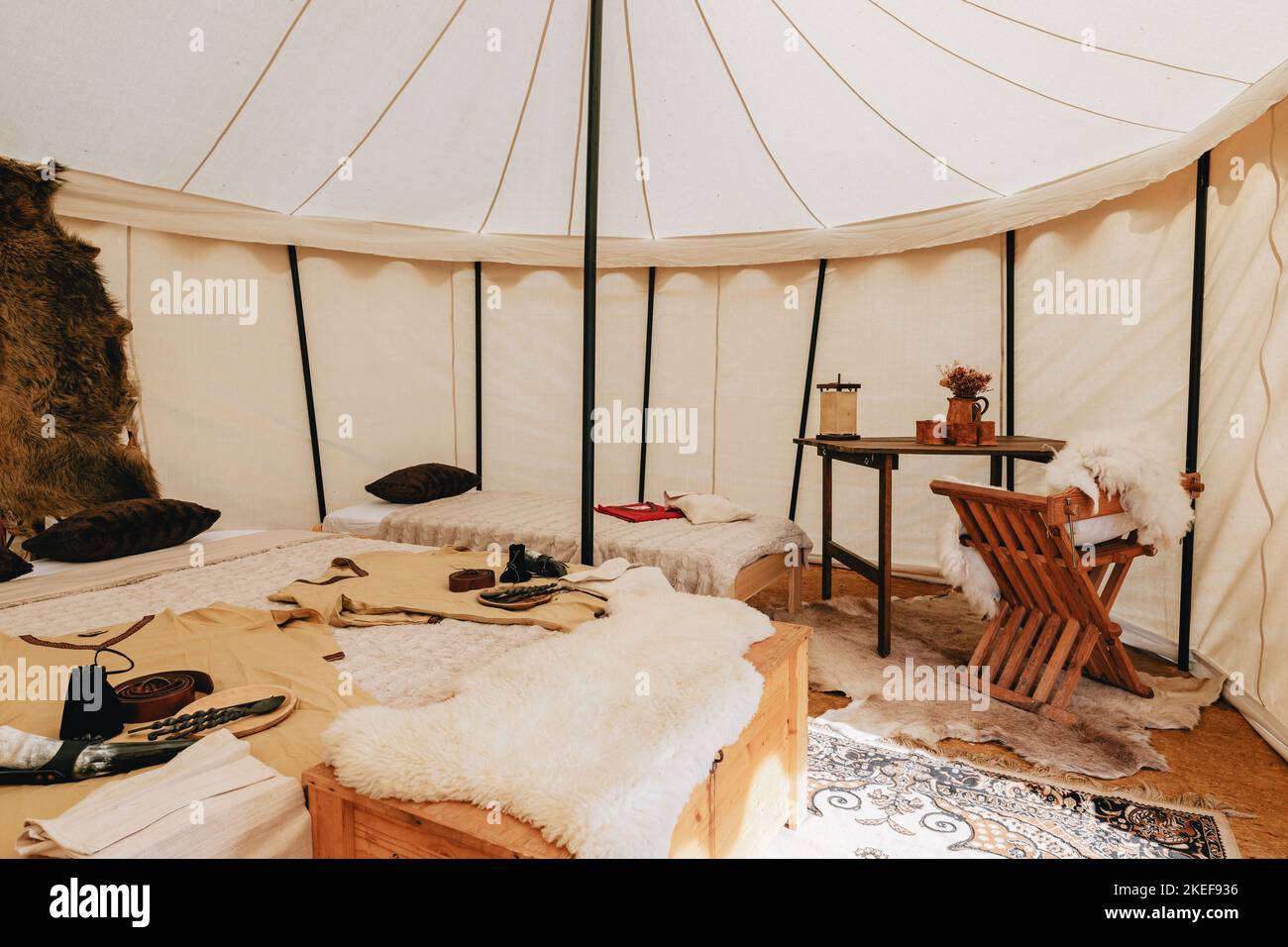 The interior of a rustic-style tent with hunting equipment and ...