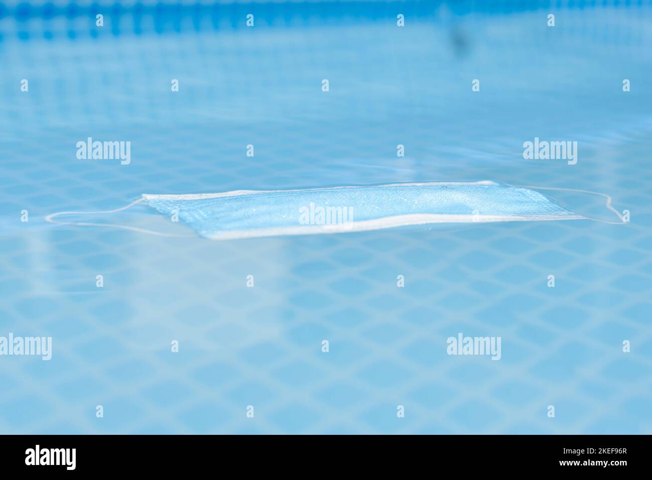 a piece of paper floating in a swimming pool, with water droplets on ...