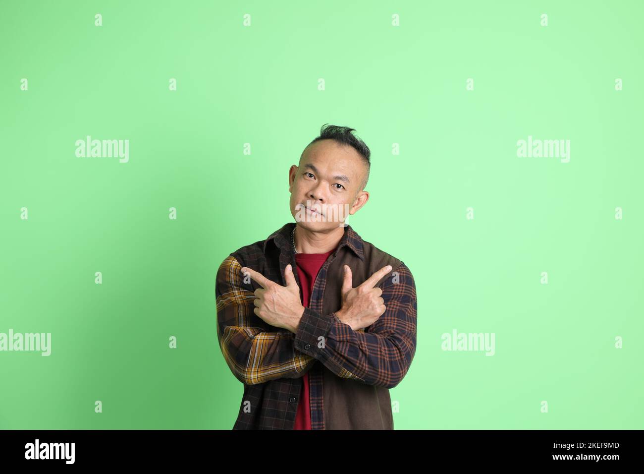 The 40s adult Asian man with plaid shirt standing on the green ...