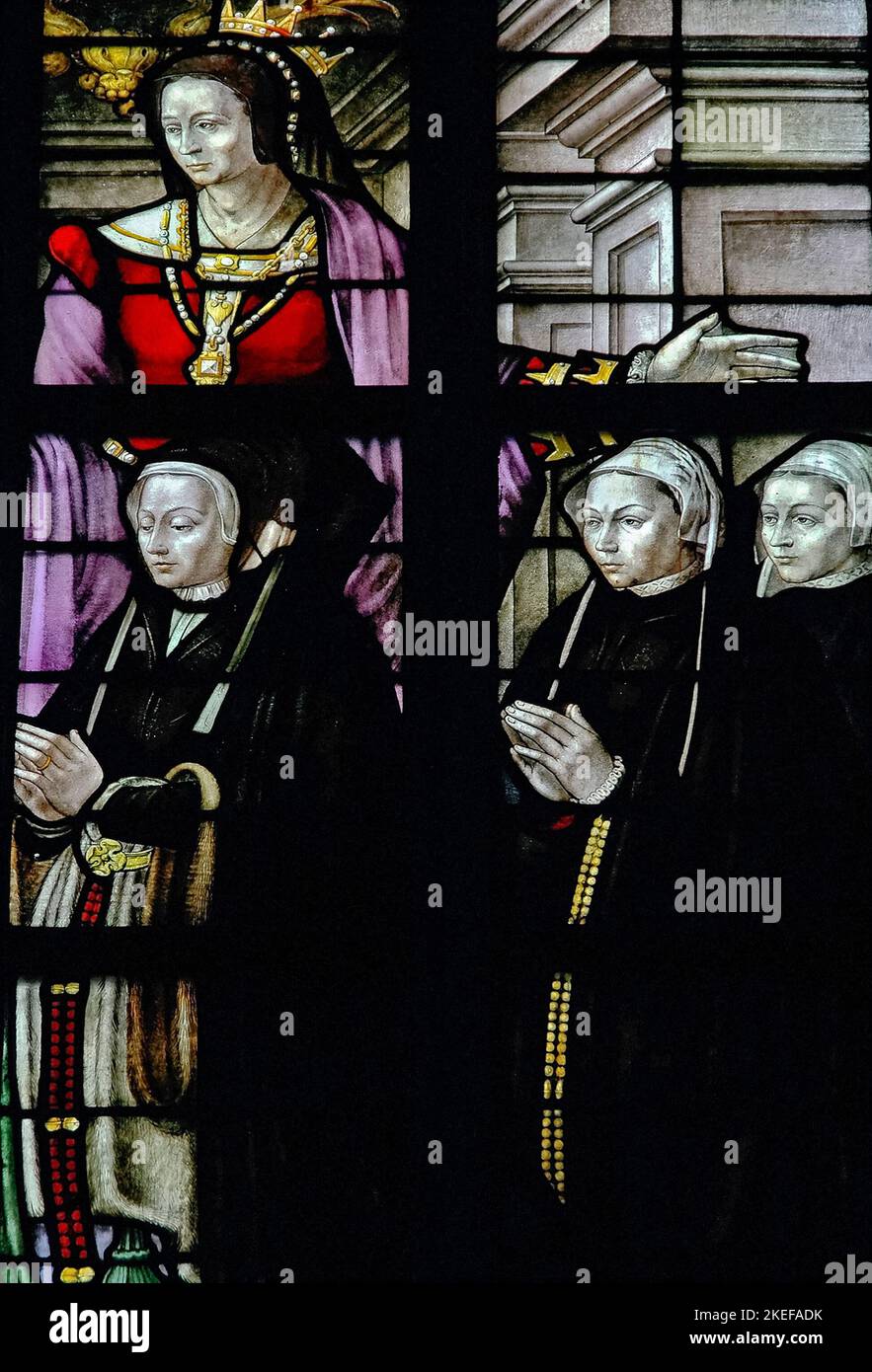 Female members of a stained glass donor’s family kneel in prayer below ...