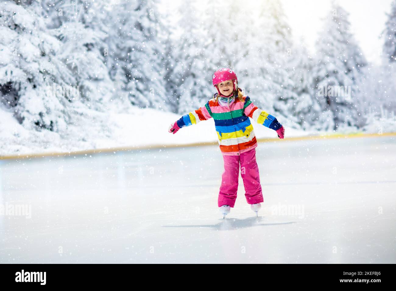 Child skating on natural ice on snowy winter day. Kids with skates ...