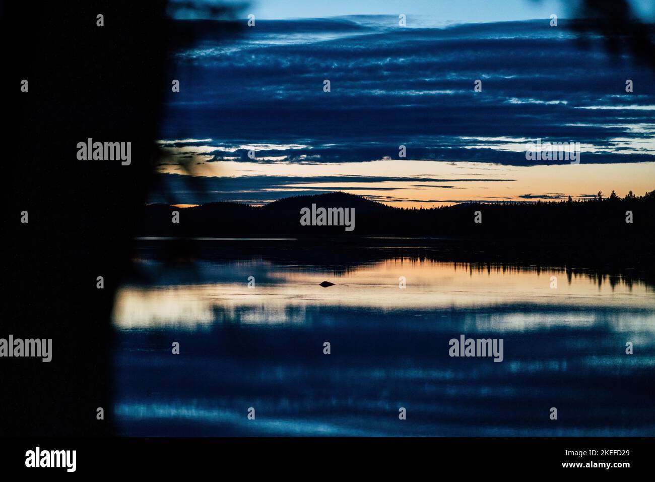 A beautiful sunset reflected on the water in Lapland, Sweden Stock ...