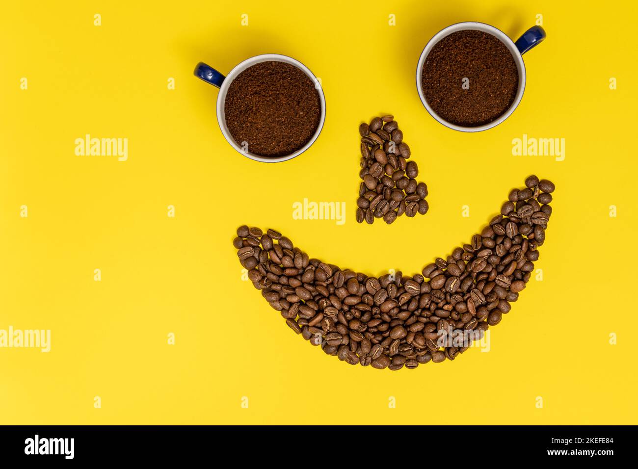 Smiling emoticon, lips made of coffee beans and eyes made of coffee ...