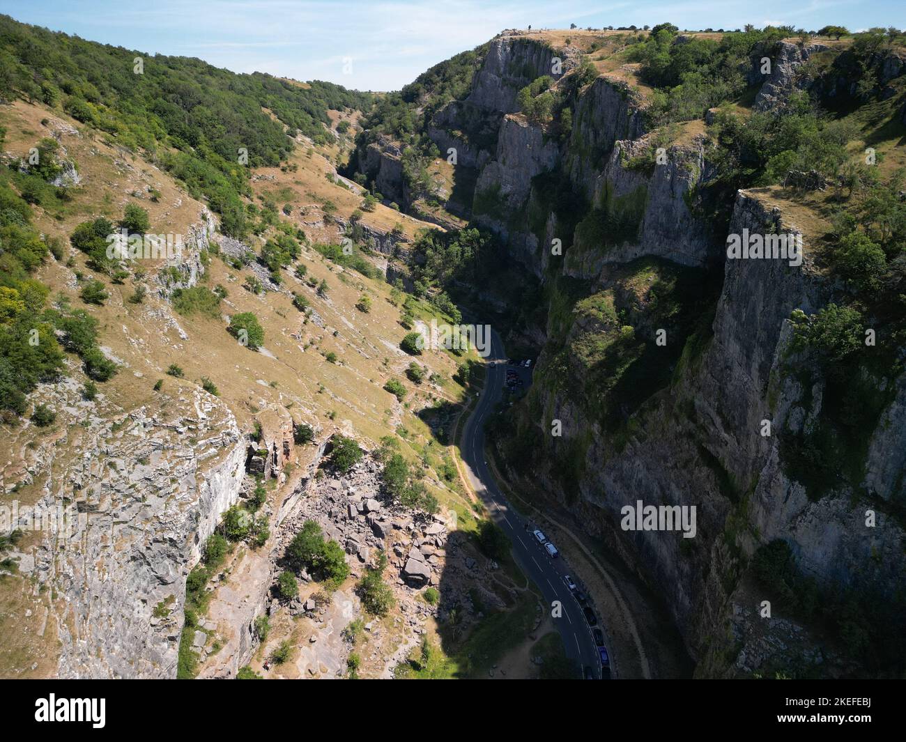 An aerial view of a road passing through a valley surrounded by tall ...