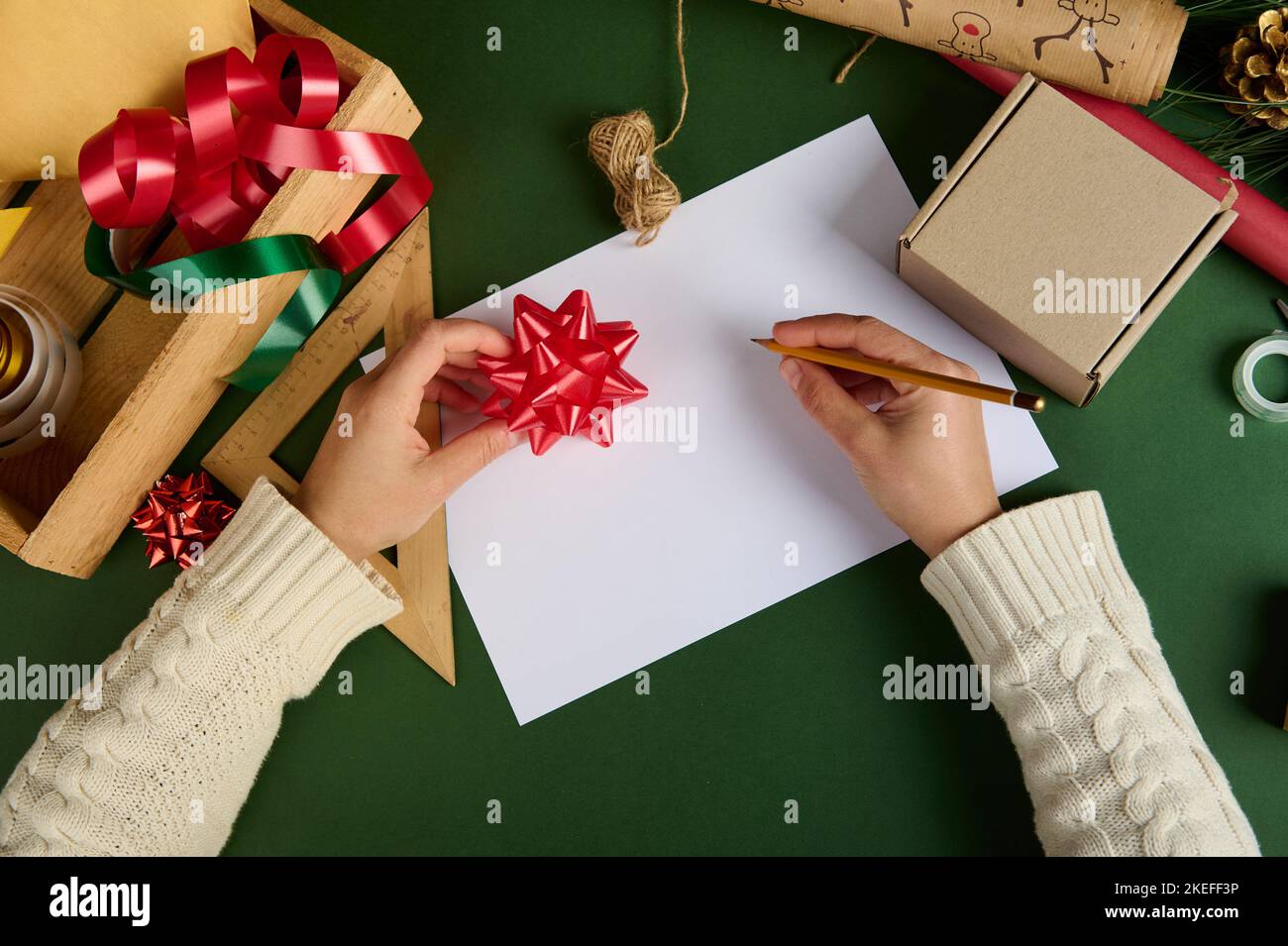 Close-up woman using a wooden crayon, drawing, writing on a white paper ...