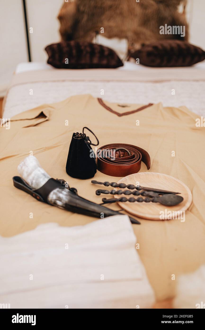 A vertical shot of a traditional robe and hunting weapons and equipment ...