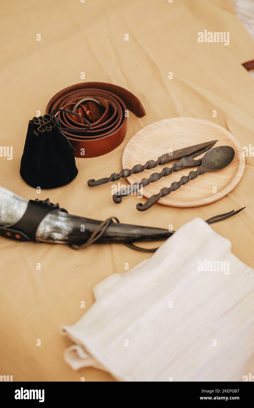 A vertical shot of a traditional robe and hunting weapons and equipment ...