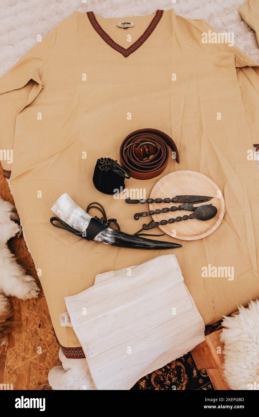 A vertical shot of a traditional robe and hunting weapons and equipment ...