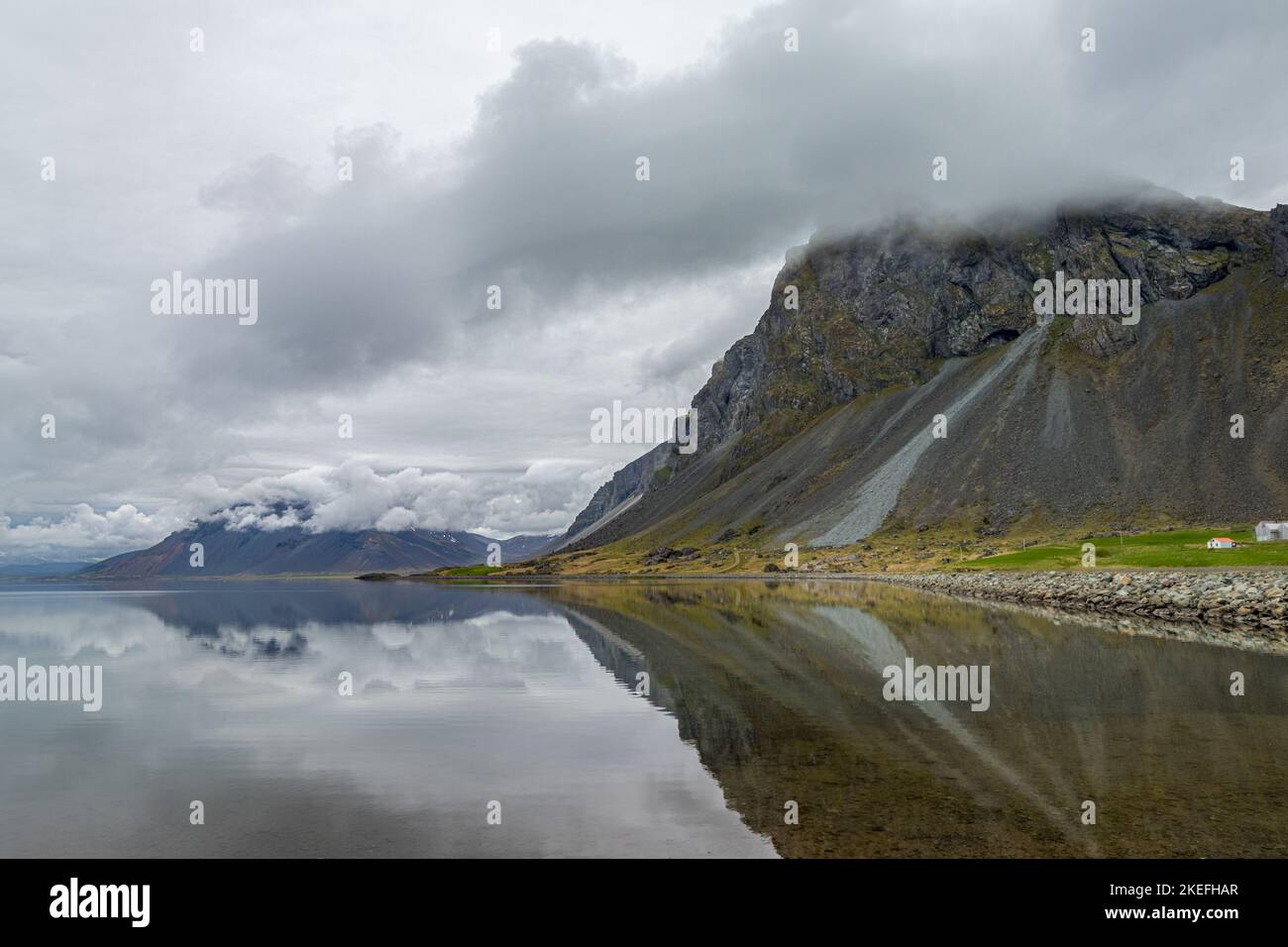 A mirror landscape in Iceland with mountains reflected on water against ...