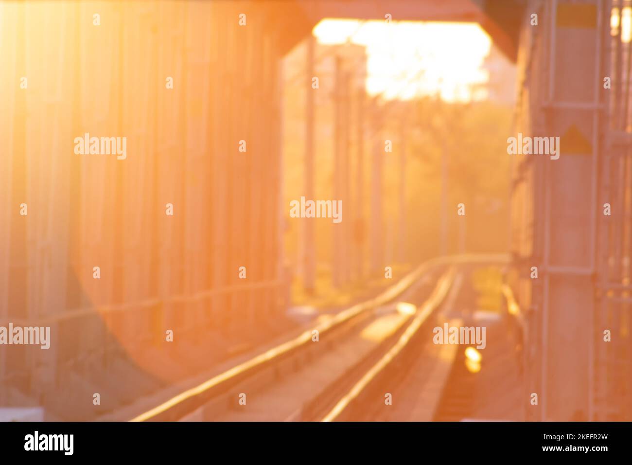 Orange glow of the sun on a blurred background of railway tracks in the ...