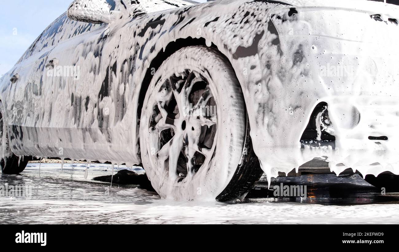 Washing luxury car on a touchless car wash. Washing sedan car with foam ...