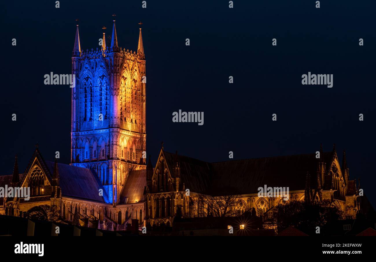 The view of Lincoln Cathedral illuminated with blue and yellow lights ...
