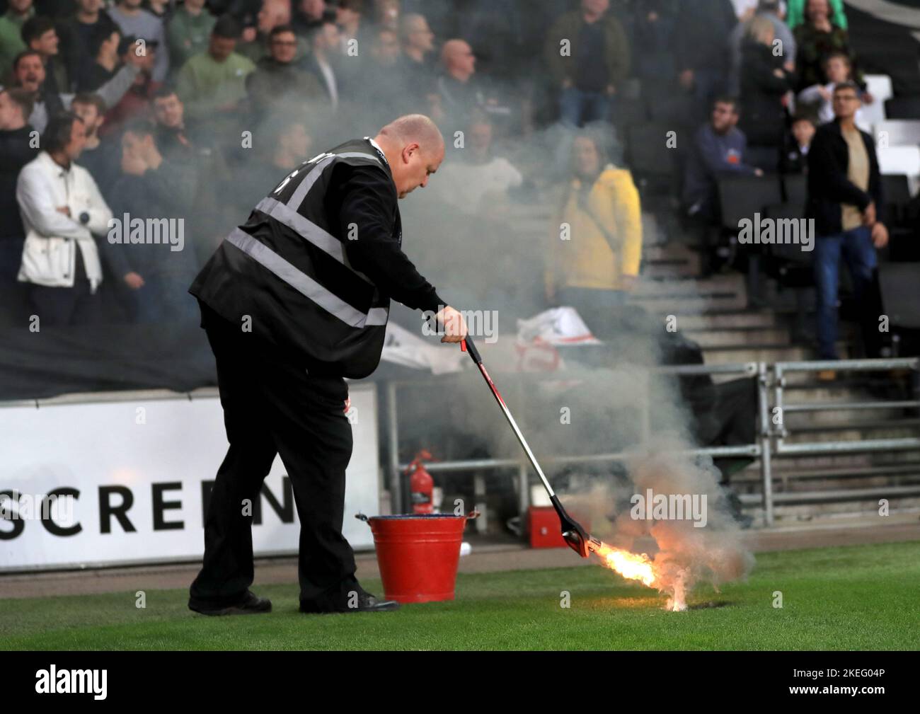 A steward removes a flare thrown onto the pitch during the Sky Bet ...