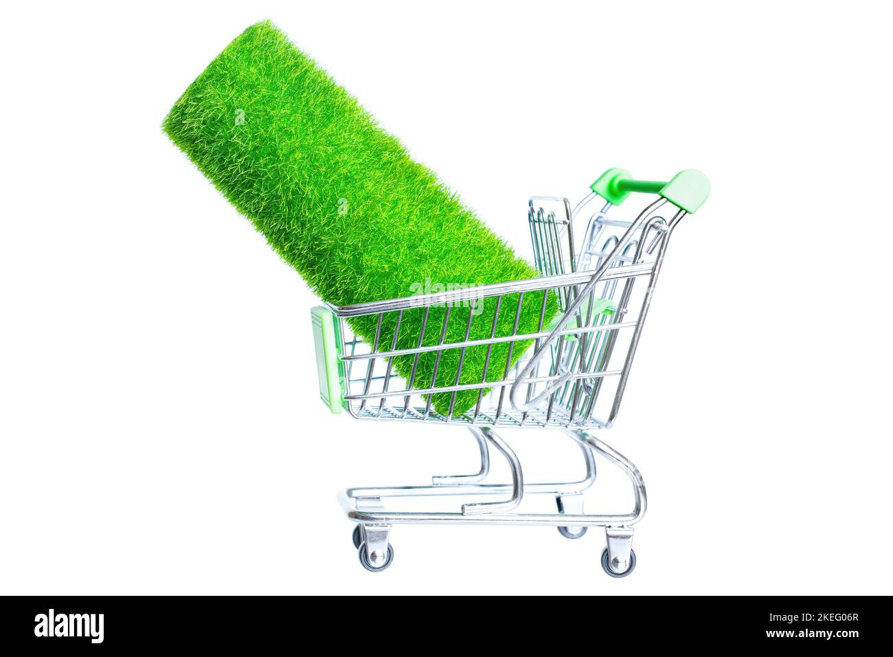 Roll of artificial grass in a toy shopping trolley isolated on white ...