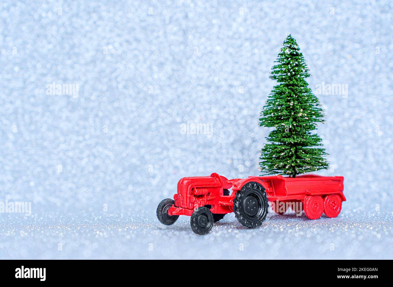 Toy red tractor with a miniature Christmas tree placed in the carriage ...