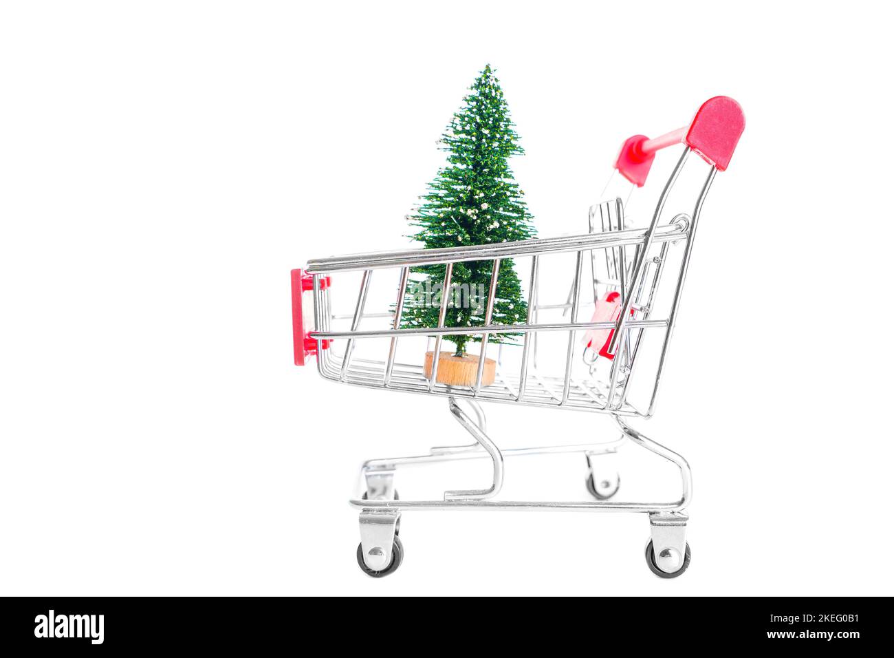 Artificial toy christmas tree placed in a miniature push cart isolated ...