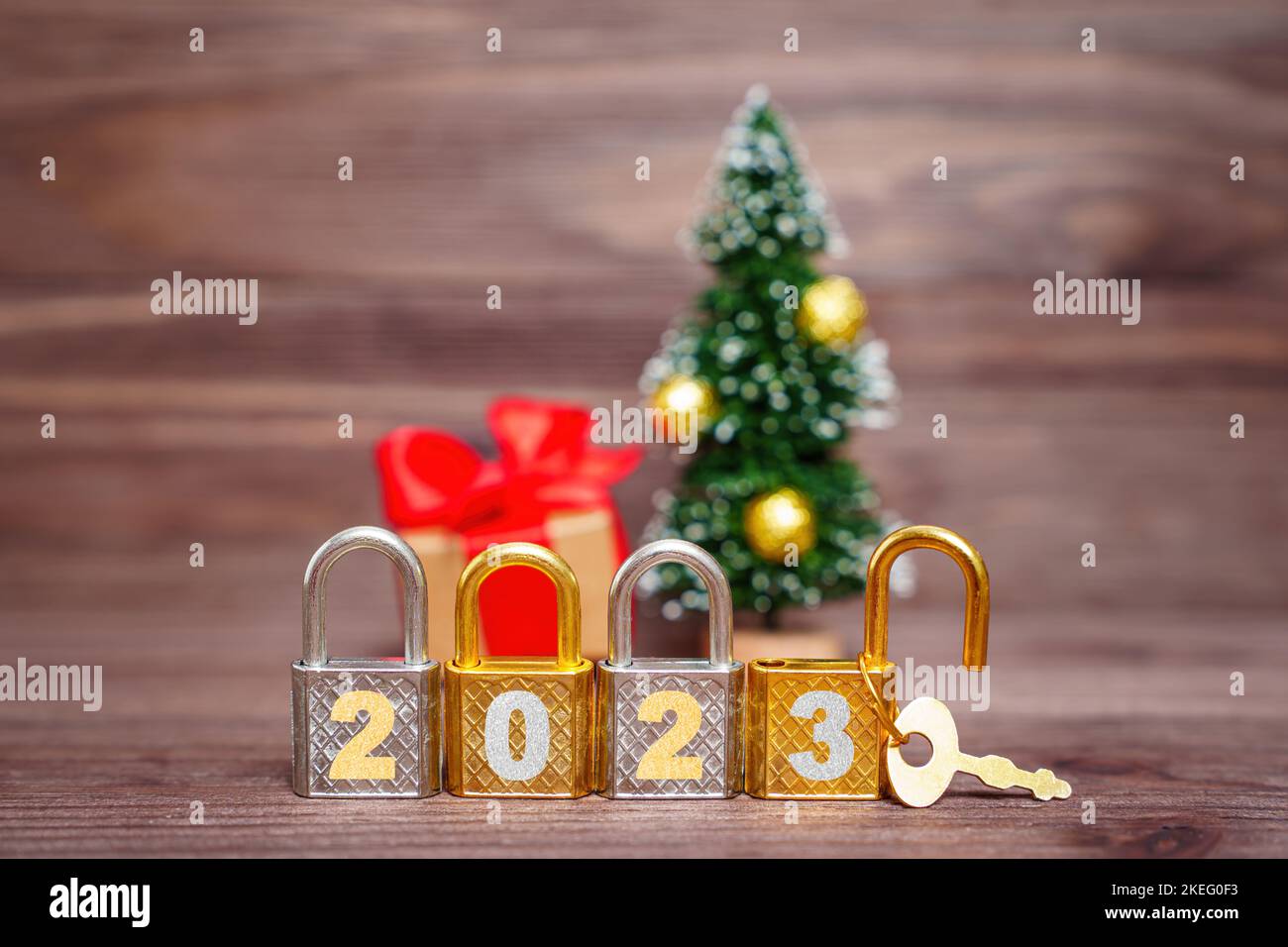 Four shiny metal padlocks labeled with 2023 digits by a toy Christmas ...